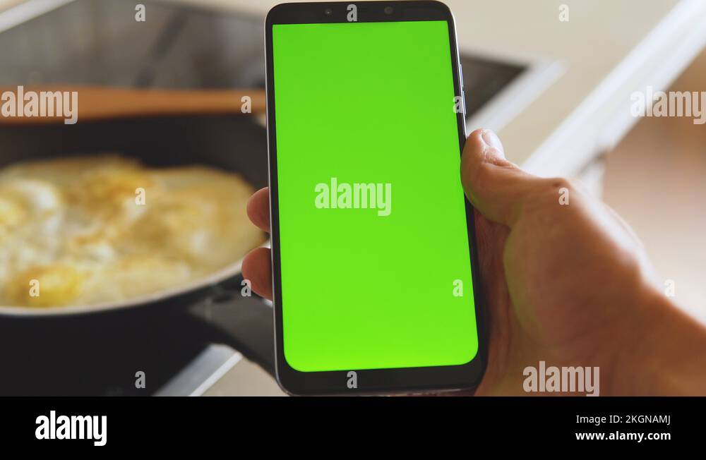 Using smartphone while cooking. Food preparation using app, green ...
