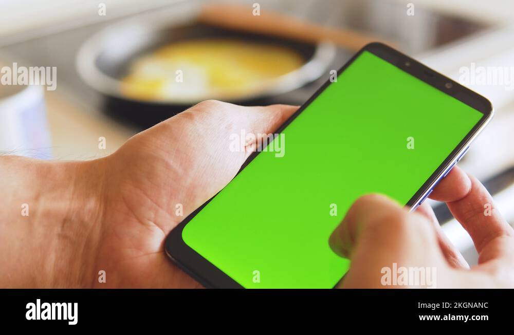 Using smartphone while cooking. Food preparation using app, green ...