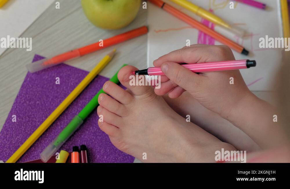 little girl draws on her feet with felt-tip pens, children's creativity ...