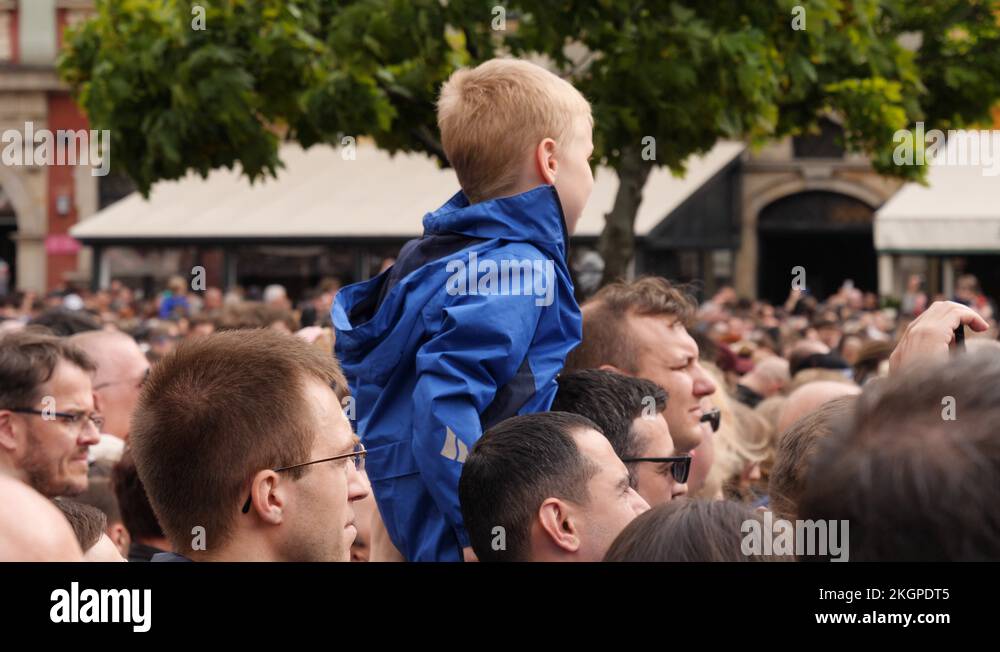 Father holding his child boy son on shoulders in street concert crowd ...