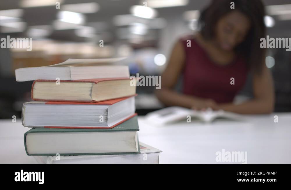 Stack of books in library with student in background 4k Stock Video ...