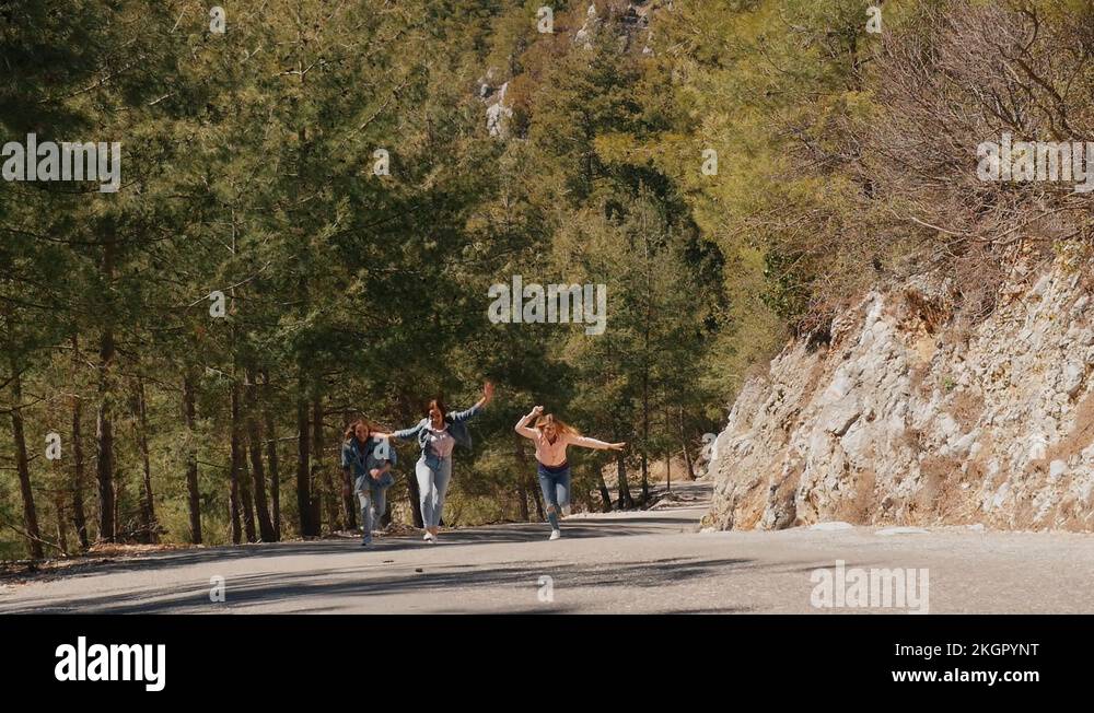 Tree young woman in jeans wear having fun on the forest road Stock ...