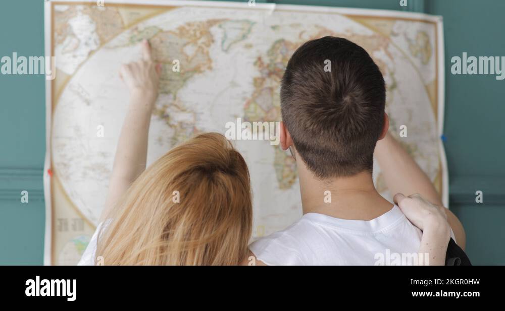 Man and woman travellers are looking at map and pointing places to ...