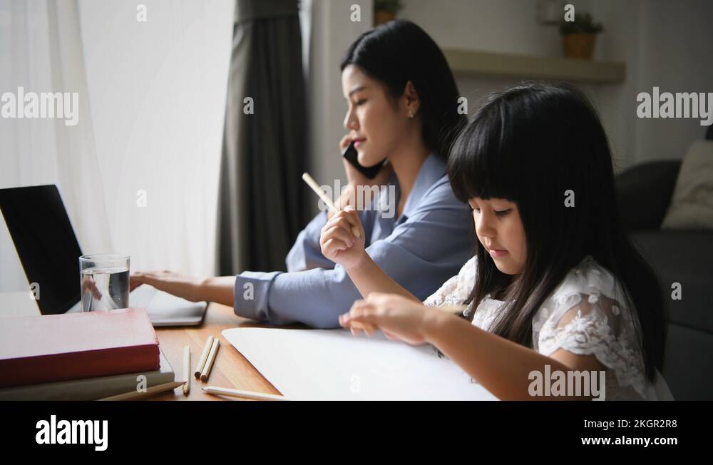 Family concept. Mom is working and taking care of her daughter too ...