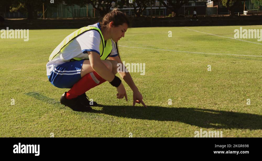 Female soccer player explaining strategy while sitting in squat ...