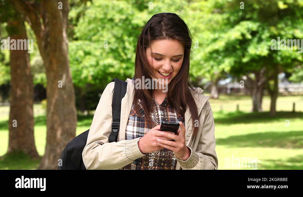 Woman laughing as she reads a text message on her mobile phone Stock ...