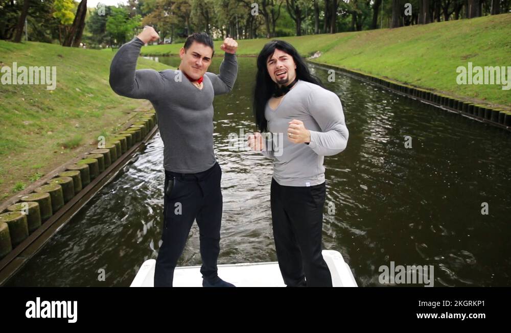 Two handsome funny guys dressed in fake muscle costumes sing and dance ...