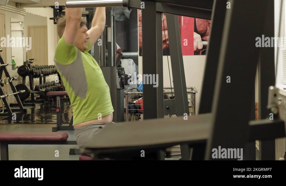 The overweight man shares the upper block in the gym. Fitness. Healthy ...