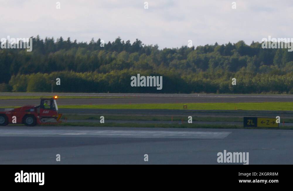 Luggage carrier vehicle moving fast on the runway to deliver luggage to ...