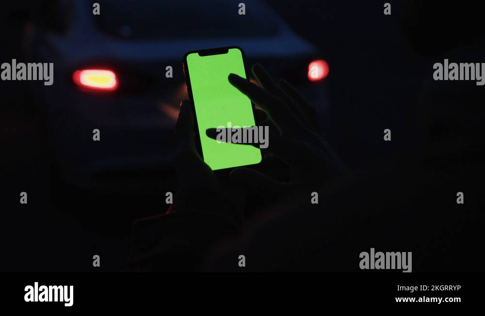 Man hand holding use smartphone with vertical green screen on night city light Stock Video ...
