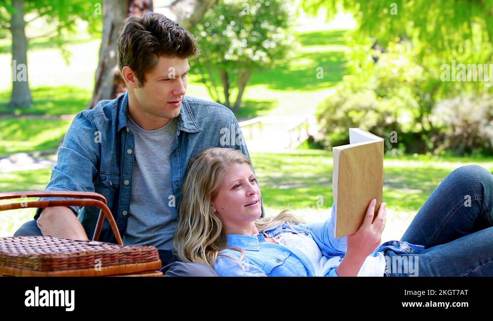 Woman reading a book while leans on her husband Stock Video Footage - Alamy