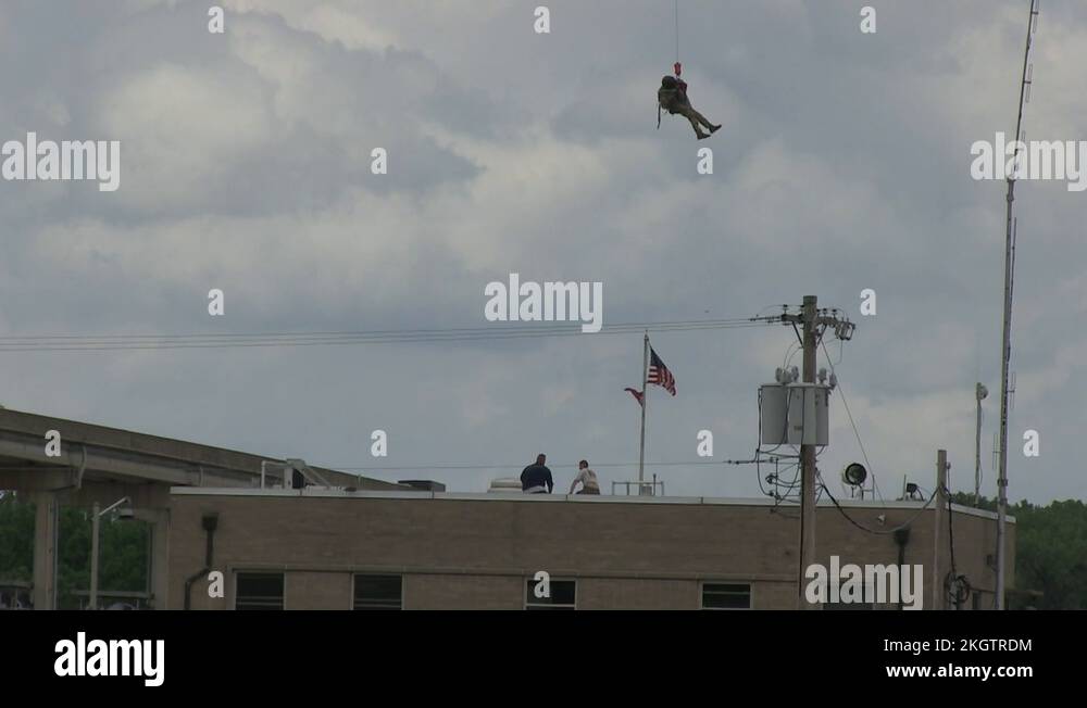 National Guard winchman descending from helicopter to conduct airlift ...