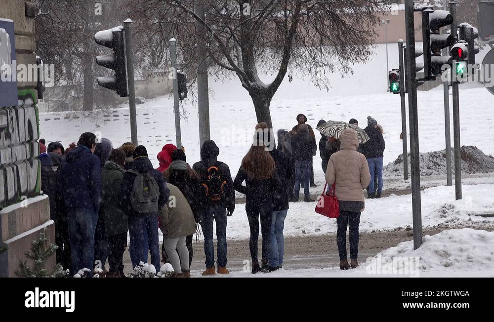 Heavy blizzard snow fall and citizen people walk through street in ...