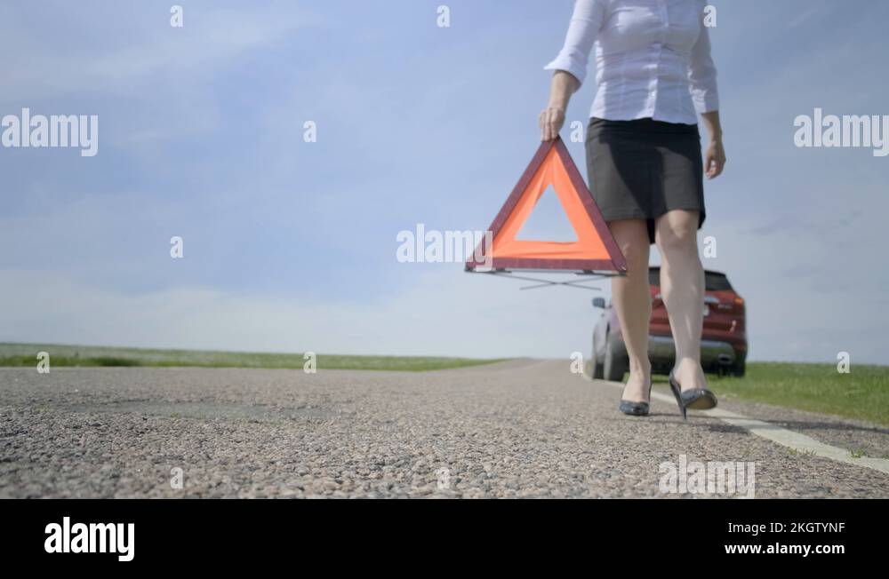 girl sets sign of emergency stop on car road. Close-up, blurred ...