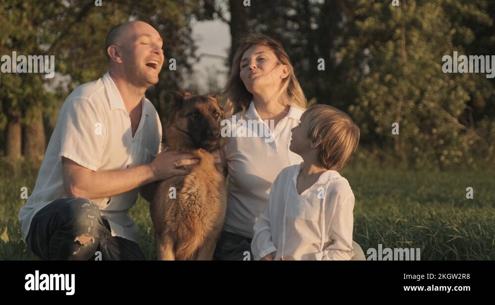 Happy family with a dog in nature. 7 year old boy with his parents ...