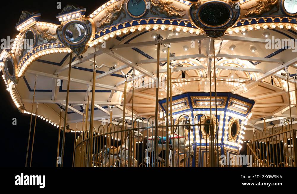Illuminated merry go round in park. Brightly illuminated roundabout ...
