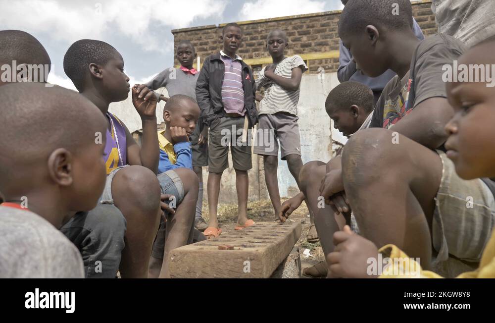 A group of African/ Kenyan children playing a game called Mancala Stock ...