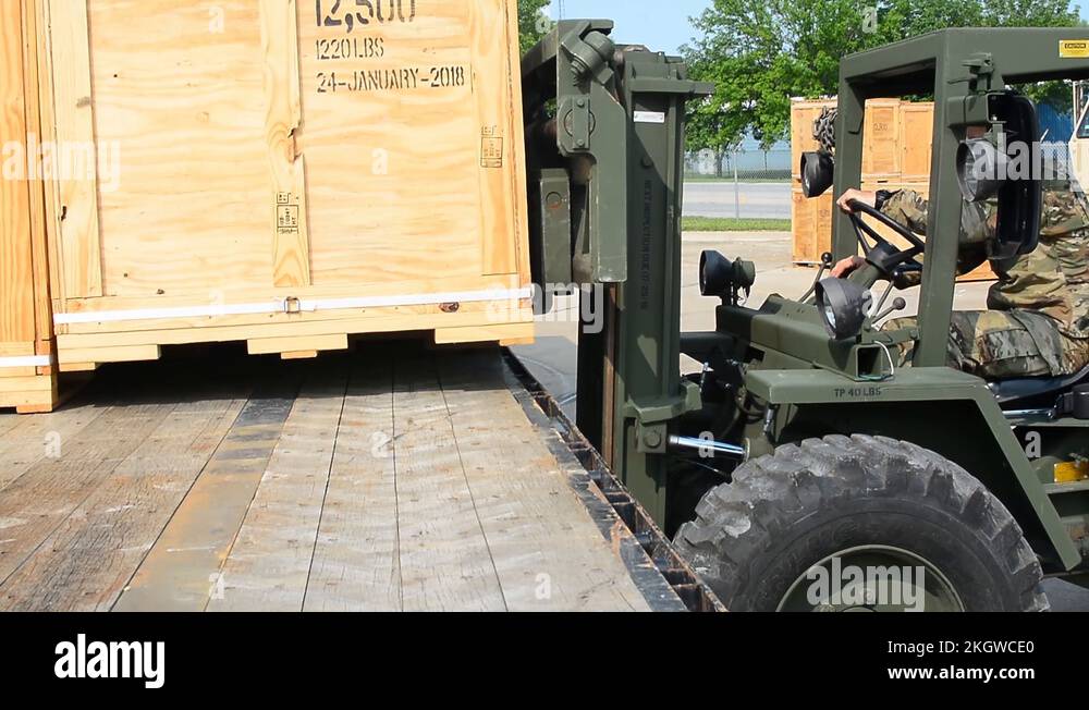 Forklift truck unloading wooden crates of sandbags from trailer Stock ...