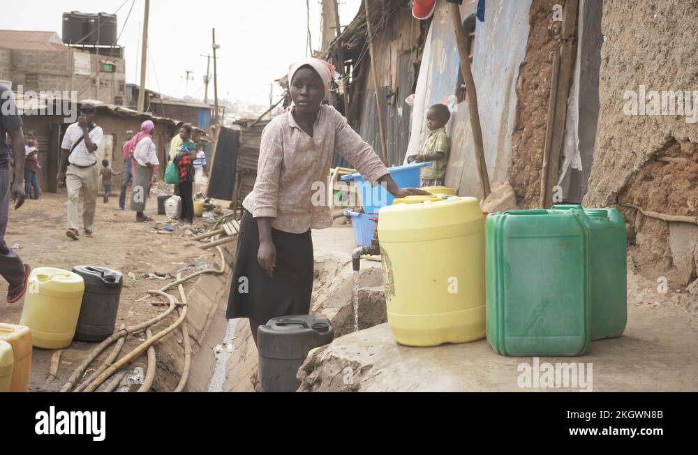 African lady filling water in the cans at water filling centre, Kenyan ...