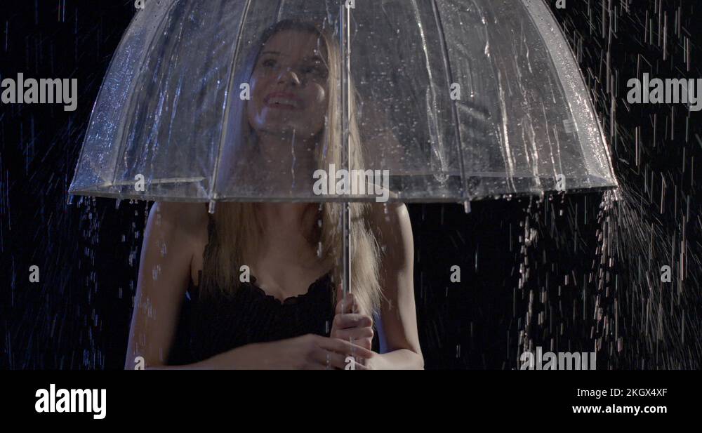 MCU woman touches transparent umbrella over face in rain at night 4K ...