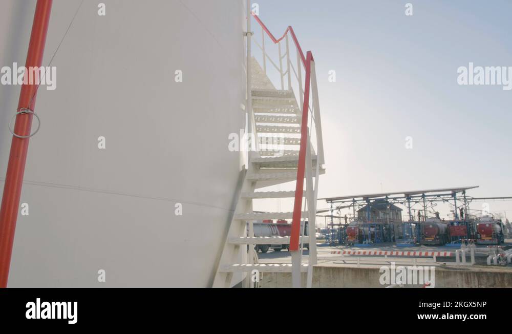 Back side view of petrochemical engineer that goes up the ladder of ...