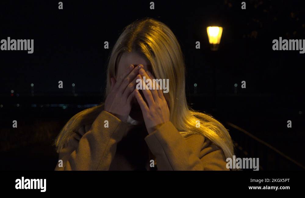 A young beautiful woman acts frustrated and sad in an urban area at ...
