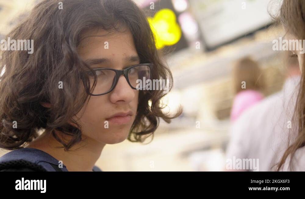 boy teenager sadly looks into the camera while at the airport. Blur ...
