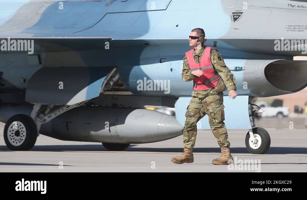 Aircraft marshaller signalling to pilot of F-16 Aggressor Stock Video ...