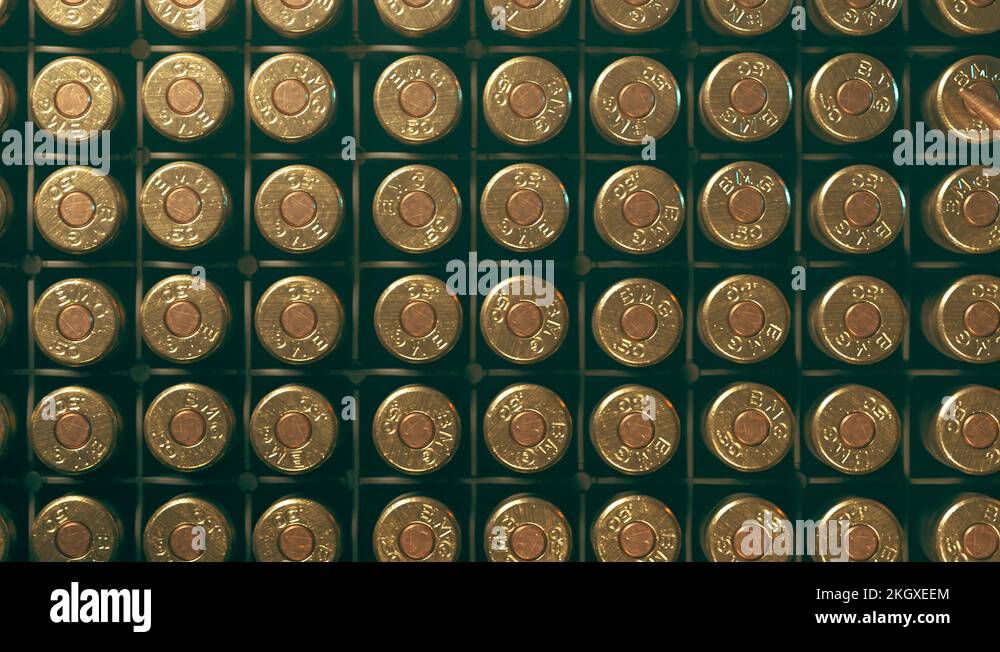 Rows of .50 BMG machine gun ammunition in plastic container. One bullet ...