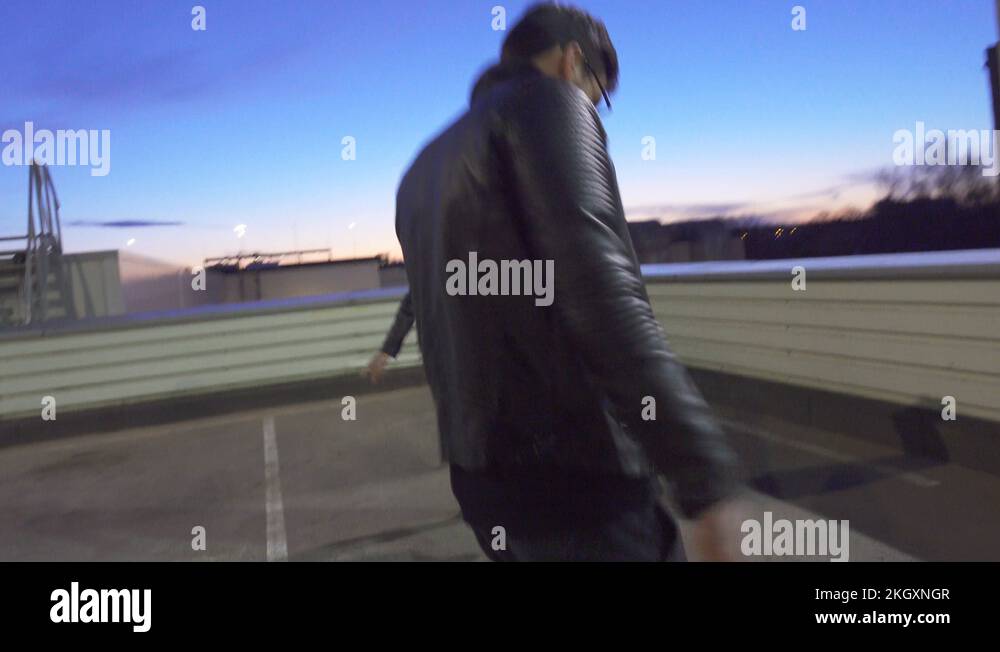 Two young men in black leather jacket are moving and dancing on floor ...