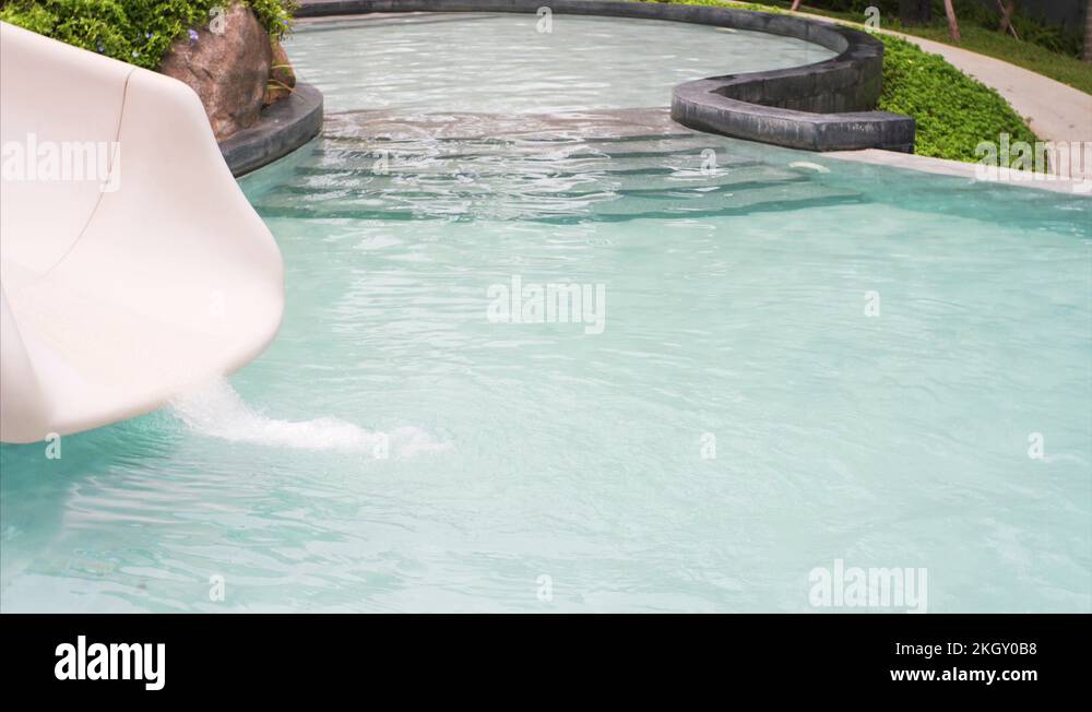 Sliding view of swimming pool with stairs and transparent water and ...