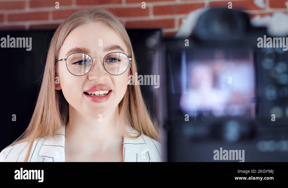 Close-up smiling face of beautiful young girl blogger talking recording ...
