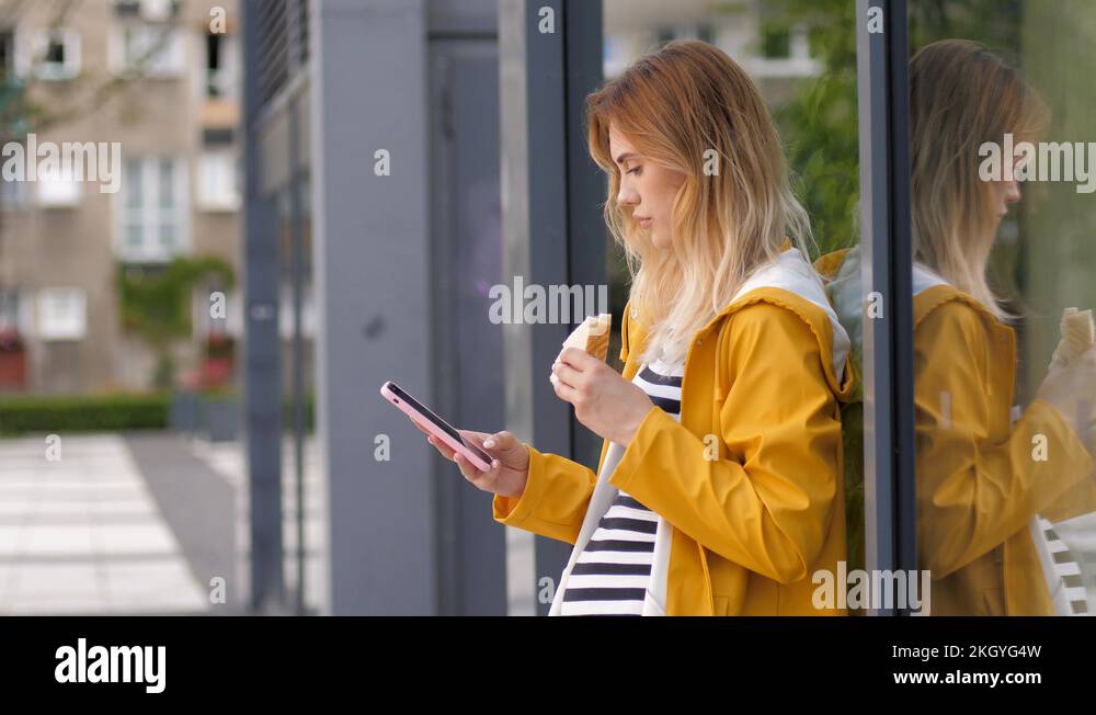 Eating sandwich young cute girl stay using mobile smartphone social ...