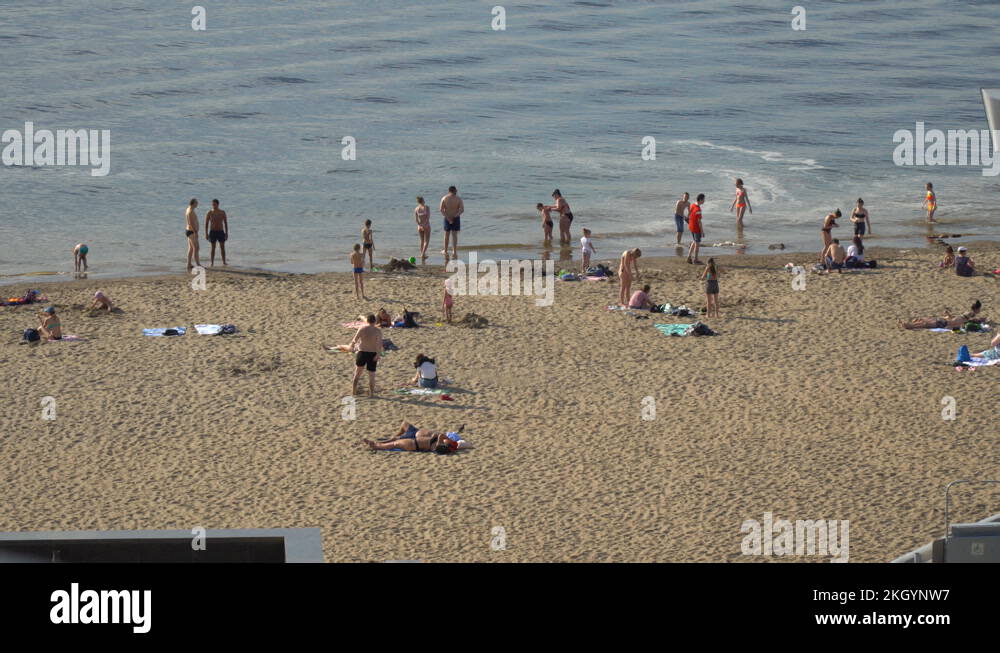 People swim and sunbathe on the beach of the Volga river embankment ...