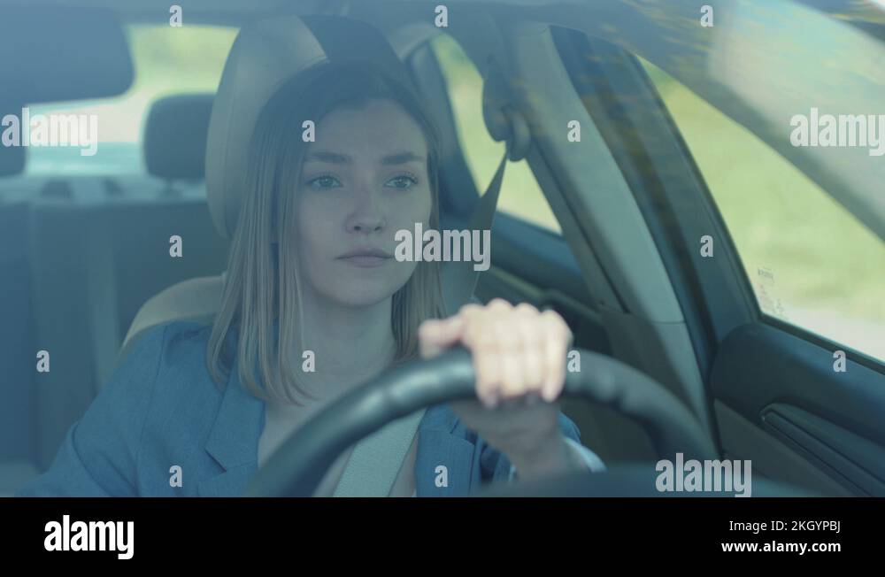 Attractive young woman driving car smile look around sing dance use ...