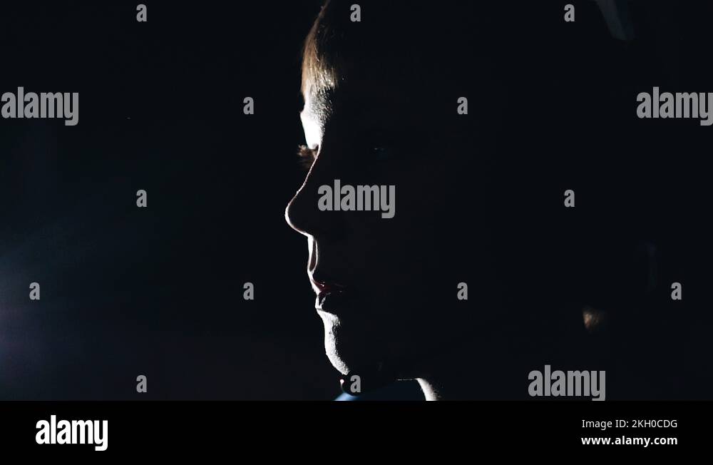 Atmospheric footage of a child's face lit by a TV in a dark room Stock ...