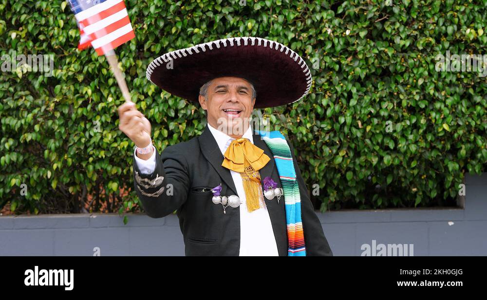 Mariachi player musician in sombrero waving American flag in Los ...