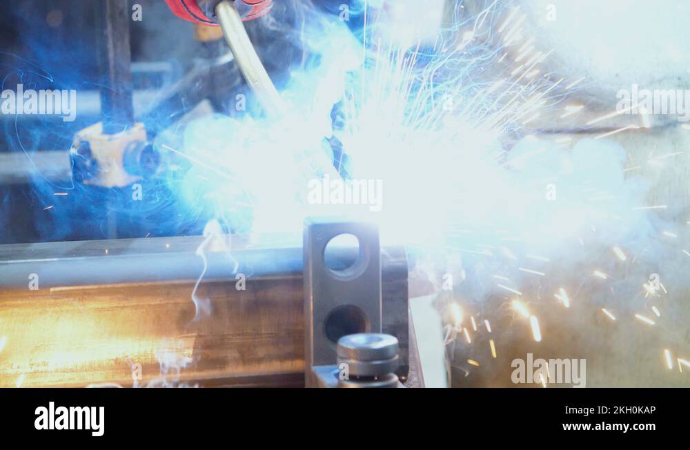 Experienced welder holding lead tip of welding gun during weld process ...