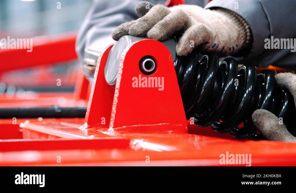 Mechanic working in assembly workshop heavy units. Fastening of shock ...