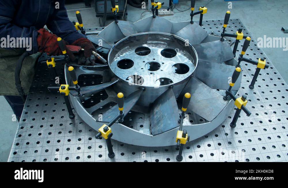 Workman making welding of channel blades of huge fan. Production of ...