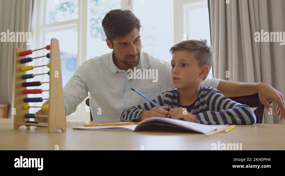 Father teaching his son mathematics with abacus in a comfortable home ...