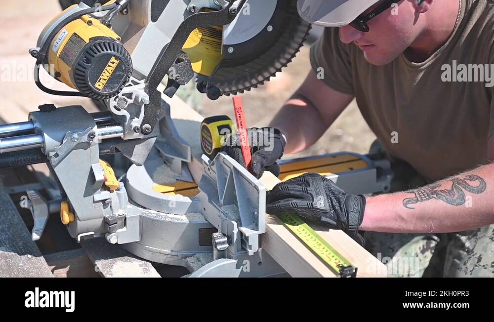 Military carpenter marking cut line on timber by circular saw Stock ...