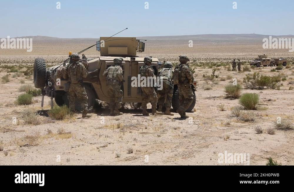Soldiers using Humvee for cover while travelling through desert on foot ...