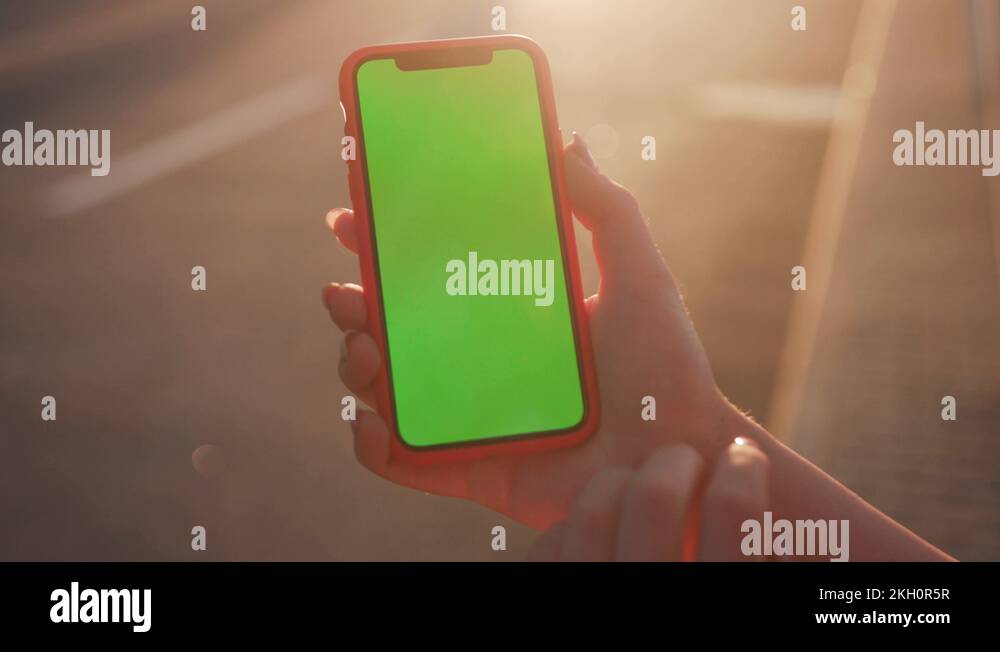 close-up female hand holding a modern smartphone with chroma green ...