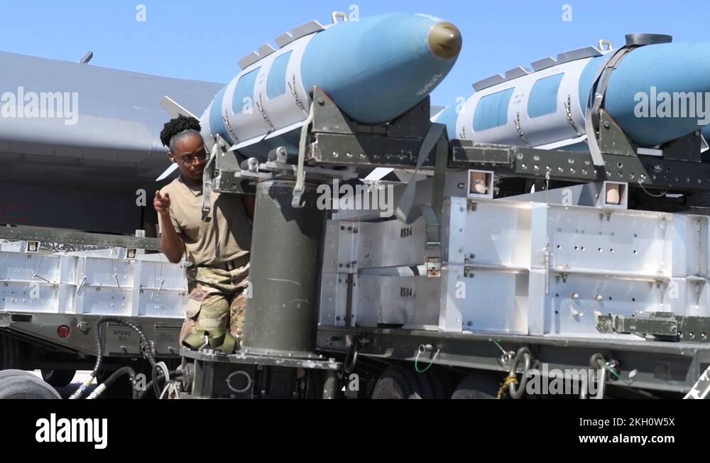 Munitions airman directing bomb loader operator during off-loading ...