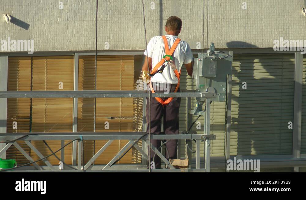 Construction worker on scaffolding repairing the building Stock Video ...
