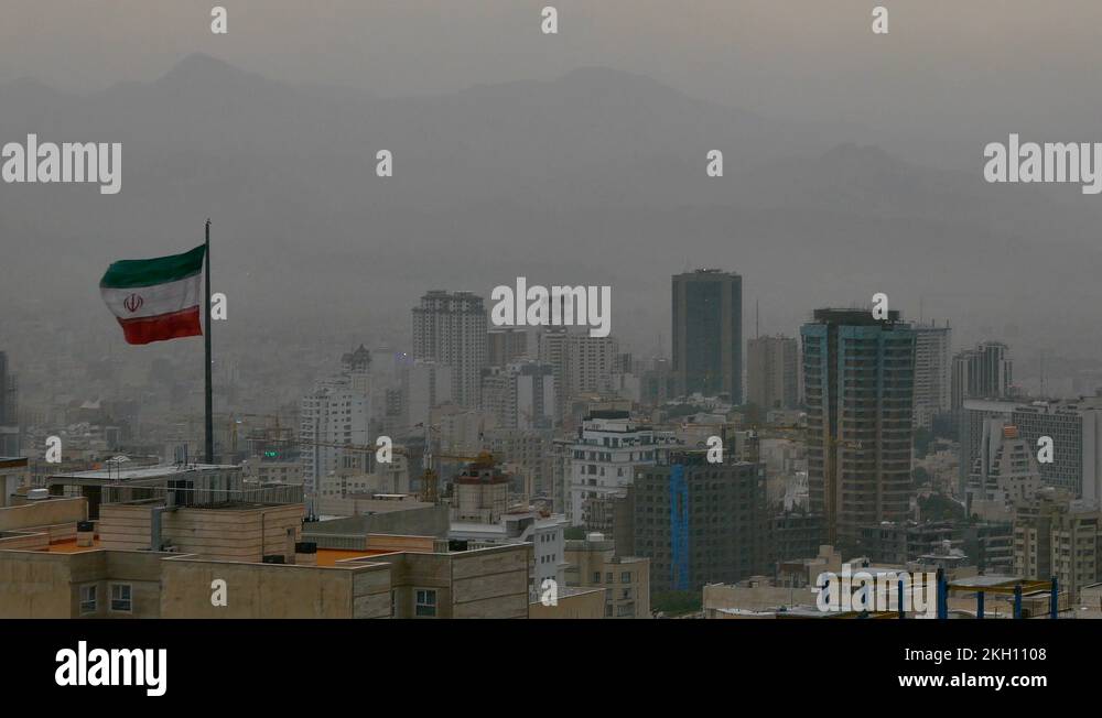 National flag of Iran waving in extreme wind during storm in middle of ...