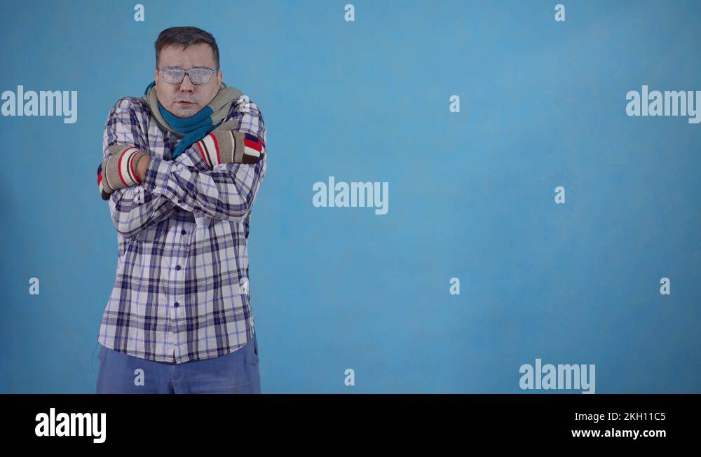 Frozen man covered in frost and wearing gloves and a scarf on a blue ...