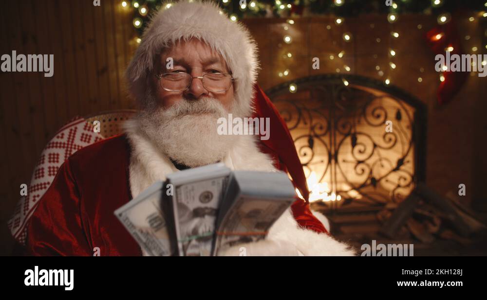 Authentic santa claus sitting in his rocker near fireplace and shaking ...