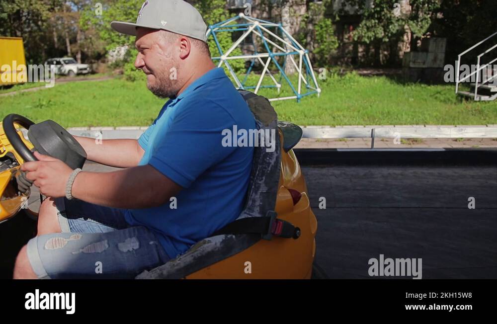 Guy and girl have fun and ride on electric cars chasing each other ...